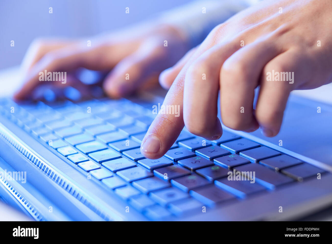 Click! Hands of a man on a keyboard with blue backlighting Stock Photo ...
