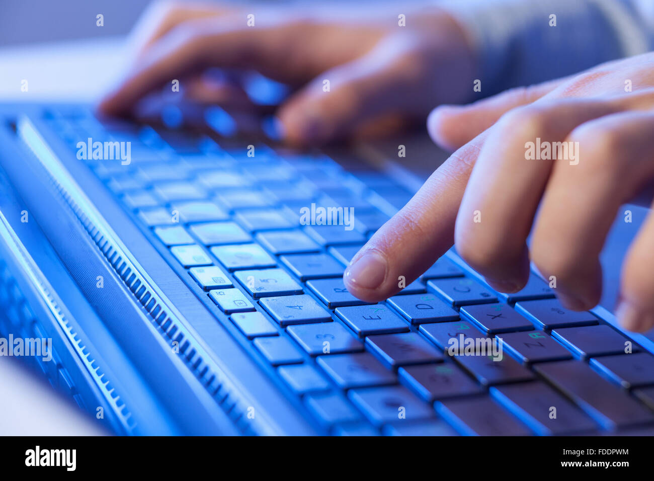 Click! Hands of a man on a keyboard with blue backlighting Stock Photo ...
