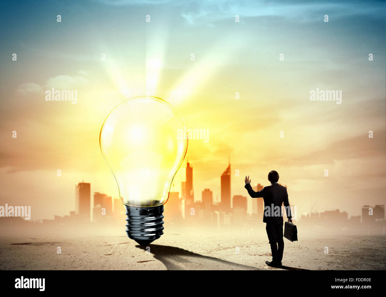 Image of businessman looking at light bulb. Green energy concept Stock ...