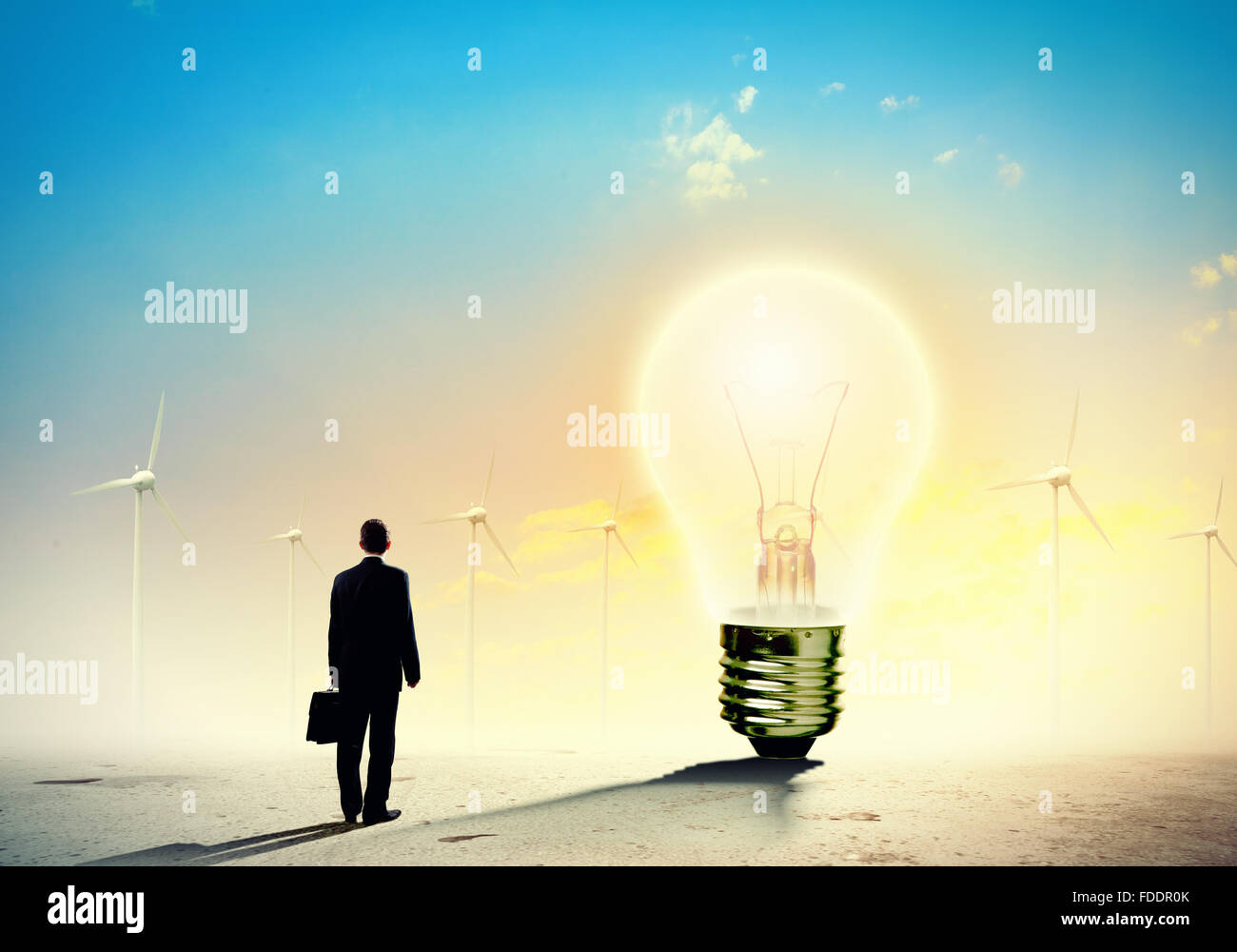 Image of businessman looking at light bulb. Green energy concept Stock ...