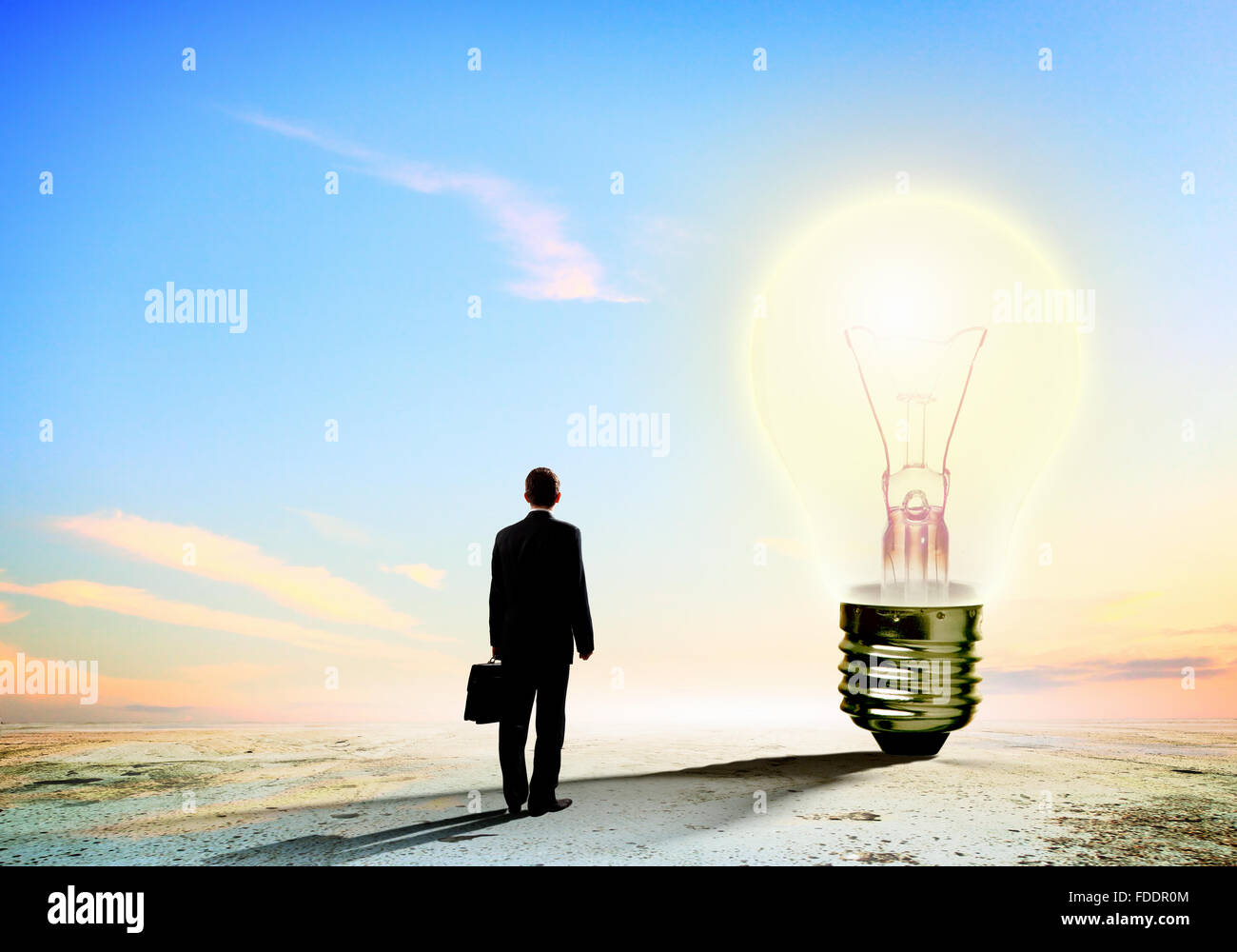 Image of businessman looking at light bulb. Green energy concept Stock ...