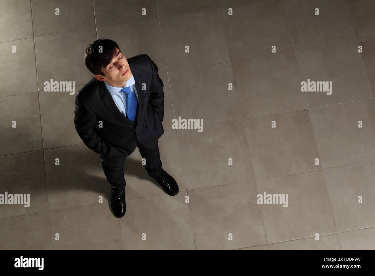 Image of young businessman with his eyes closed looking above. Top view ...