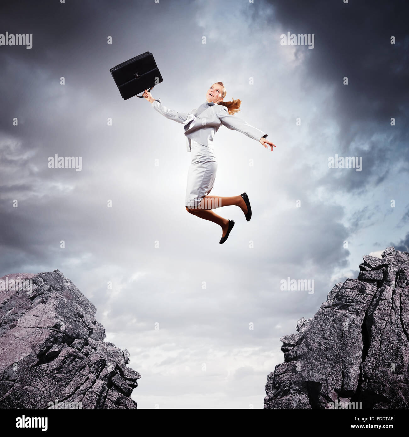 Image of young businesswoman jumping over gap Stock Photo - Alamy