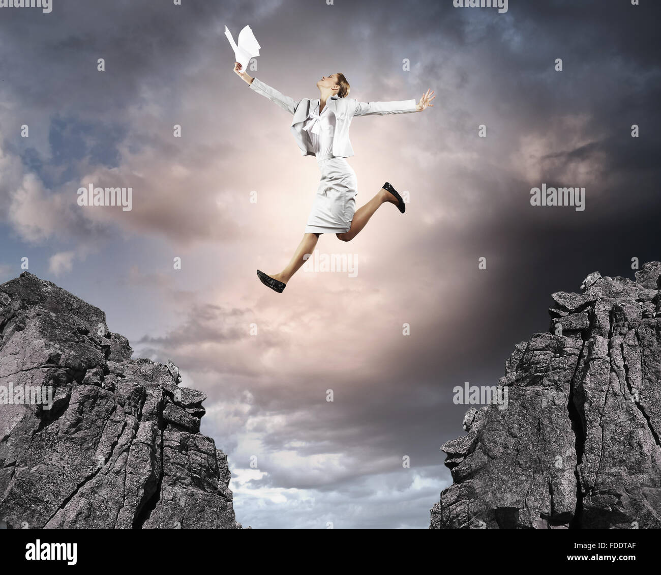 Image of young businesswoman jumping over gap Stock Photo - Alamy