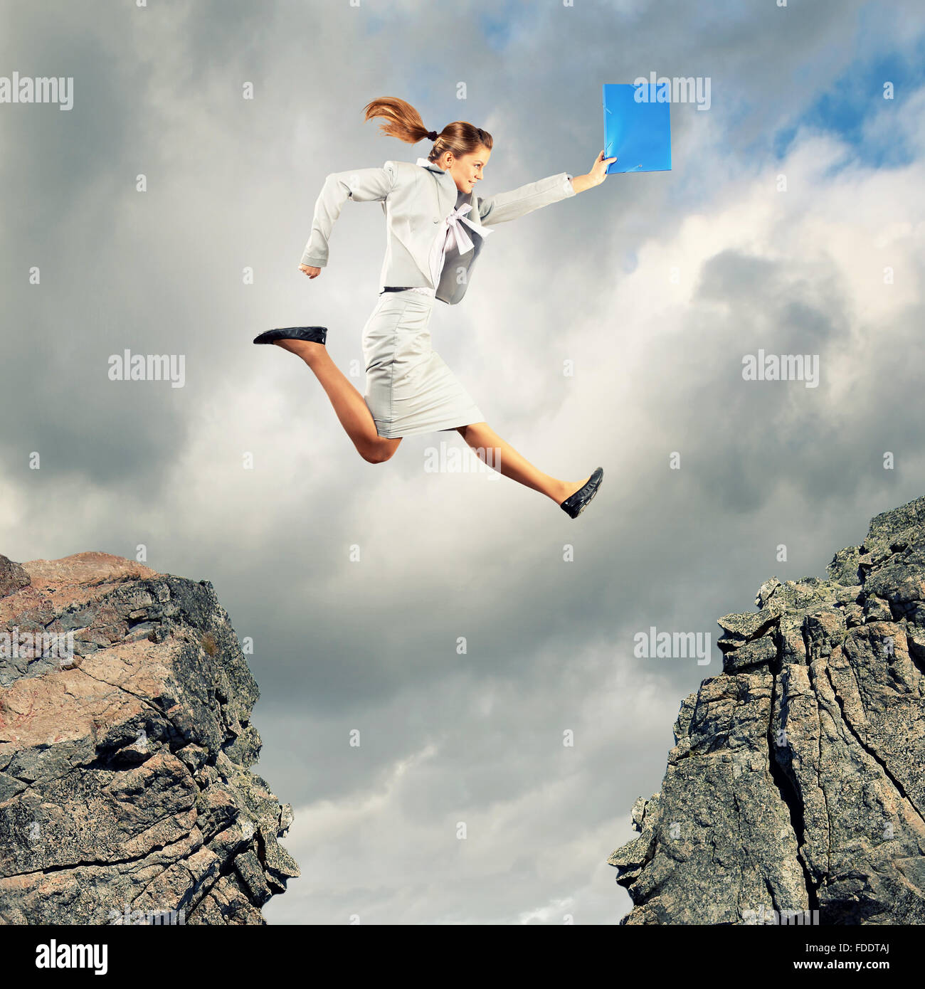 Image of young businesswoman jumping over gap Stock Photo - Alamy
