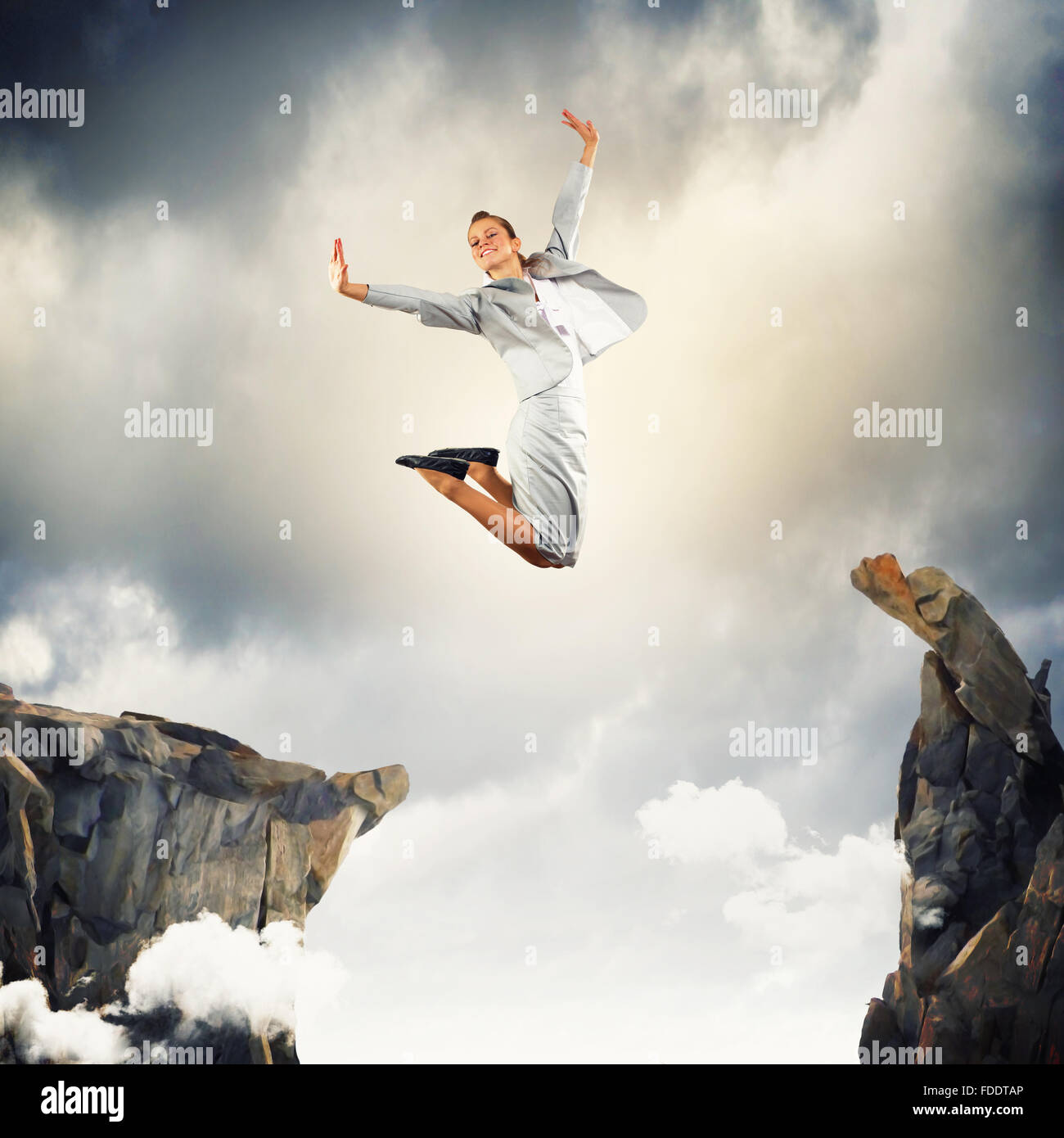Image of young businesswoman jumping over gap Stock Photo - Alamy