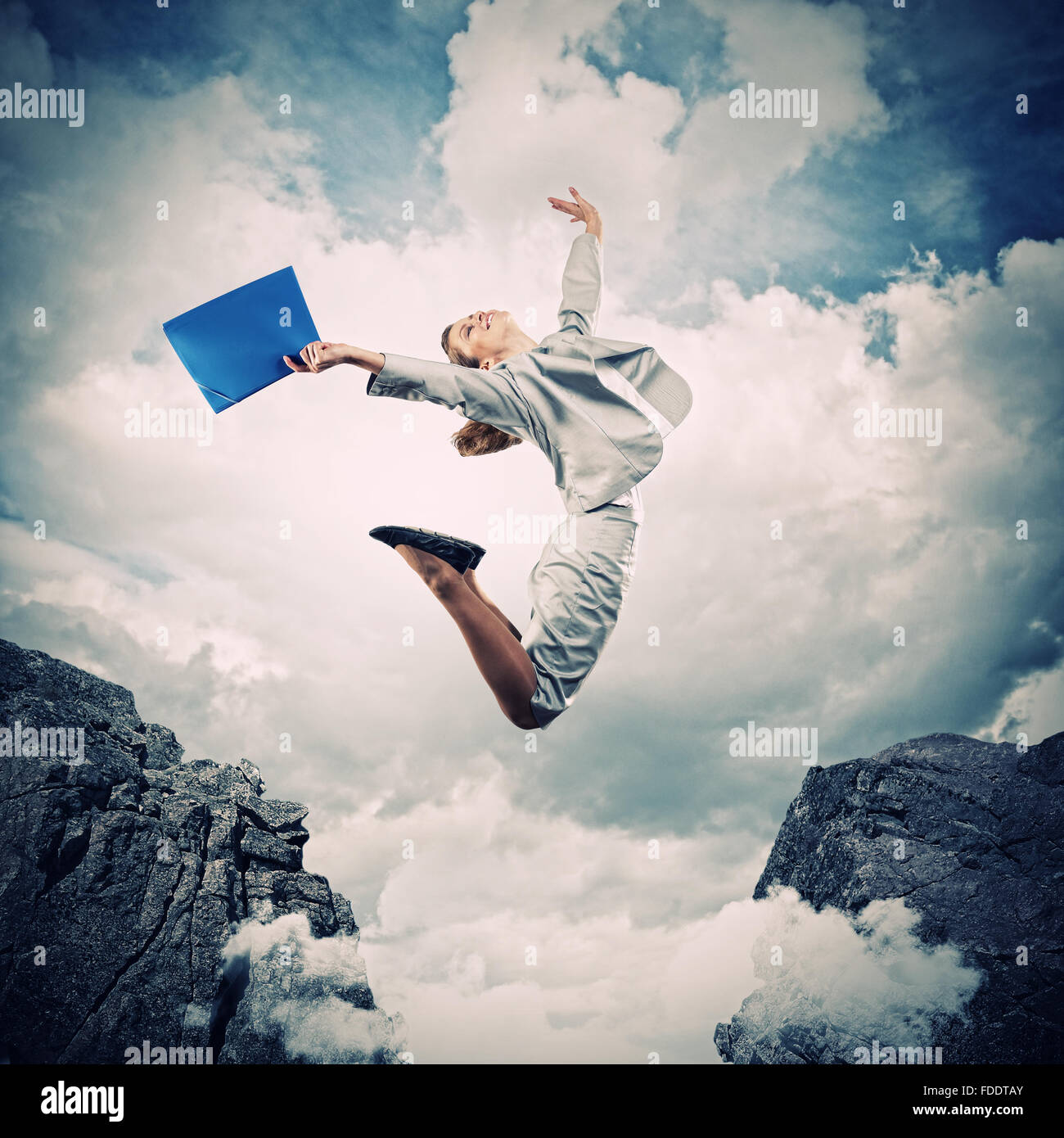 Image of young businesswoman jumping over gap Stock Photo - Alamy