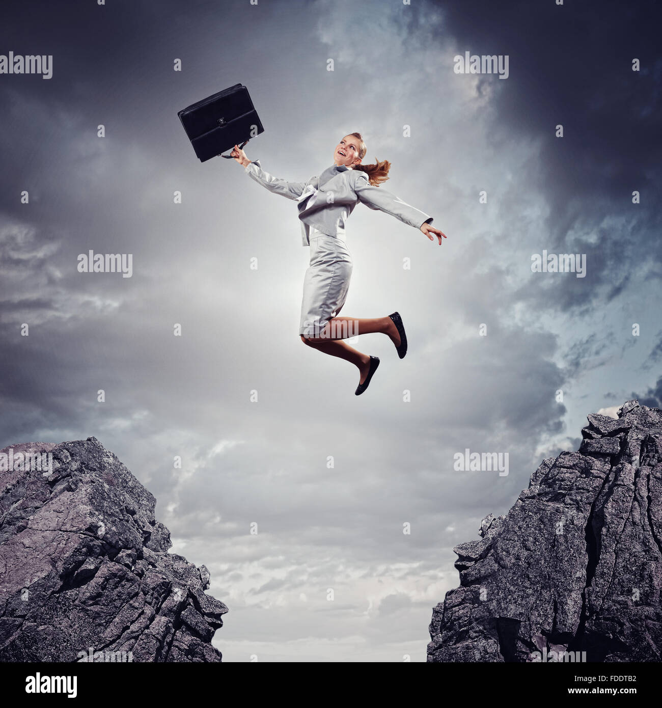 Image of young businesswoman jumping over gap Stock Photo - Alamy