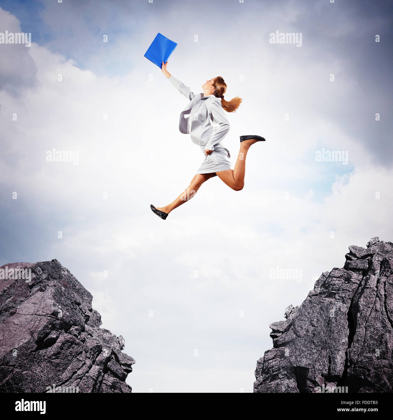 Image of young businesswoman jumping over gap Stock Photo - Alamy