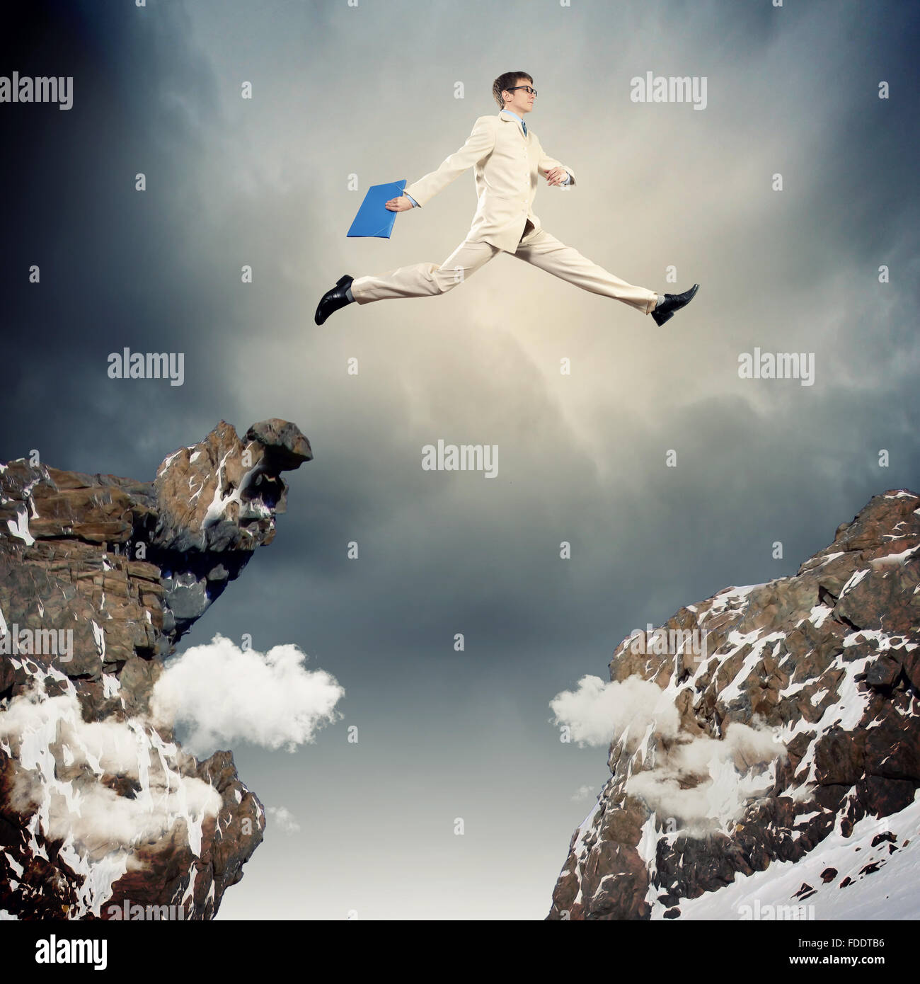Image of young businessman jumping over gap Stock Photo - Alamy
