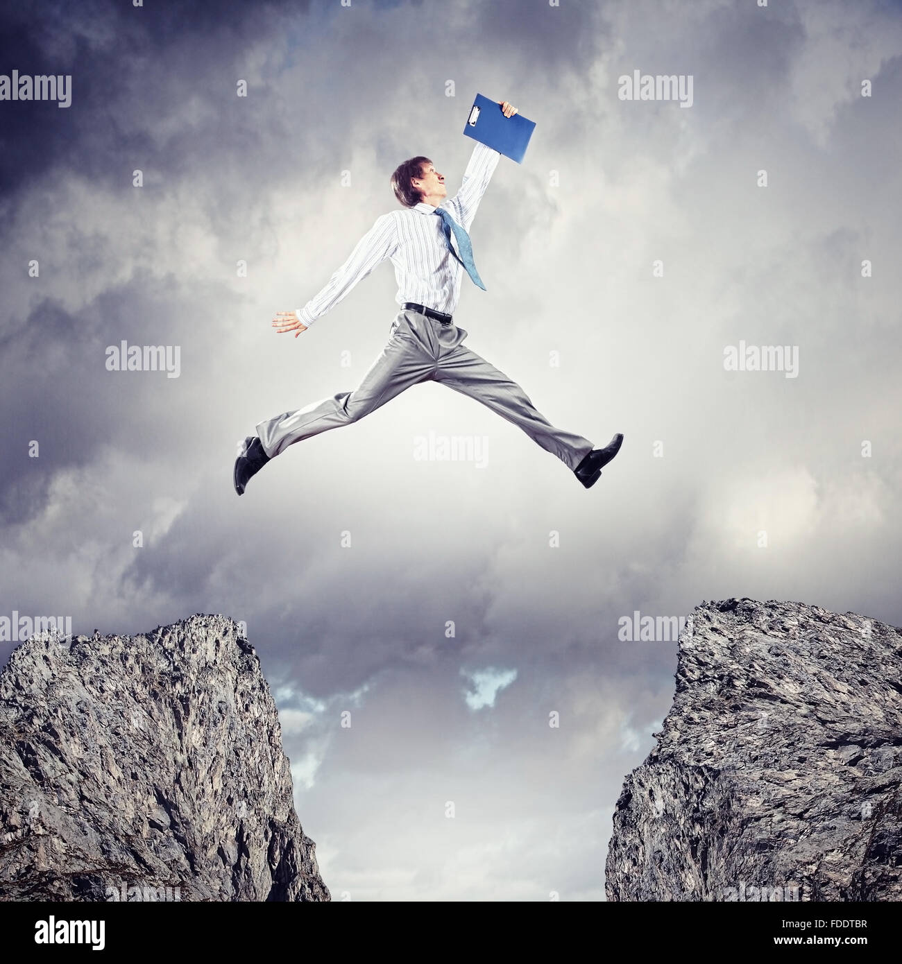 Image of young businessman jumping over gap Stock Photo - Alamy