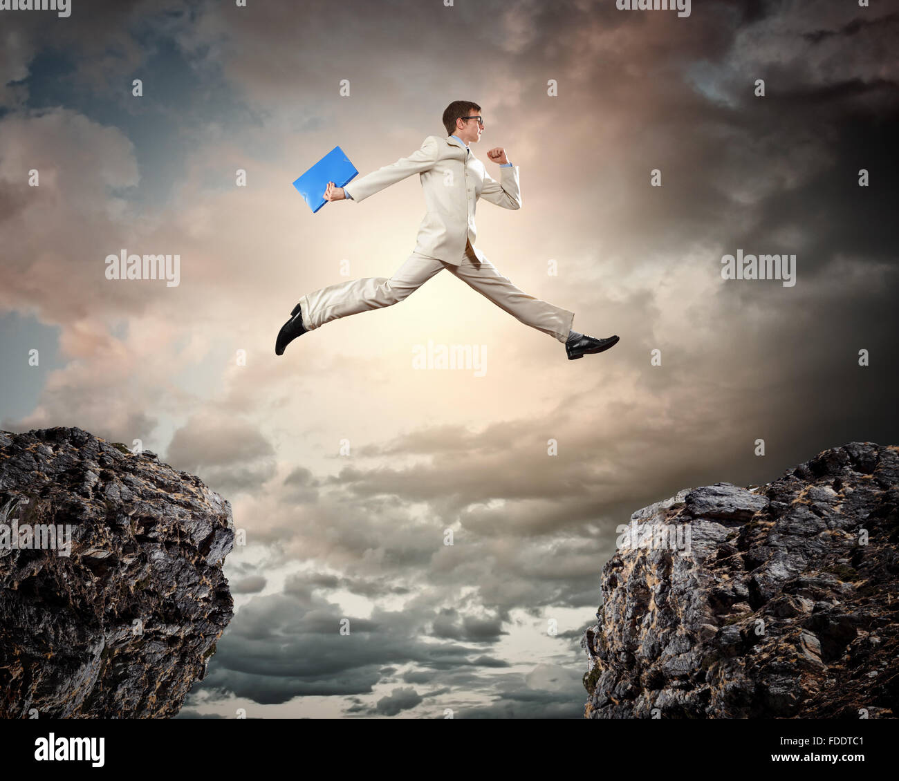 Image of young businessman jumping over gap Stock Photo - Alamy