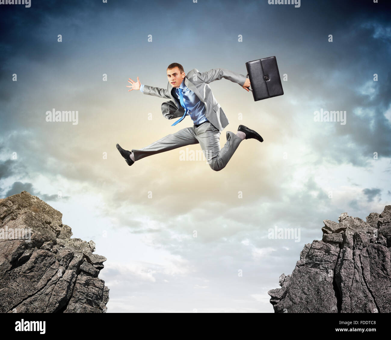 Image of young businessman jumping over gap Stock Photo - Alamy