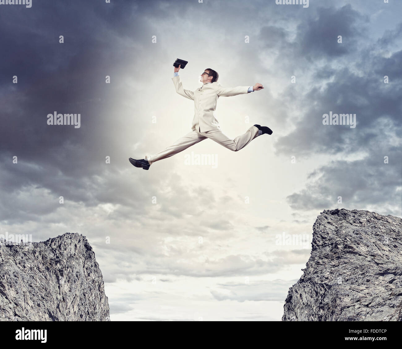 Image of young businessman jumping over gap Stock Photo - Alamy