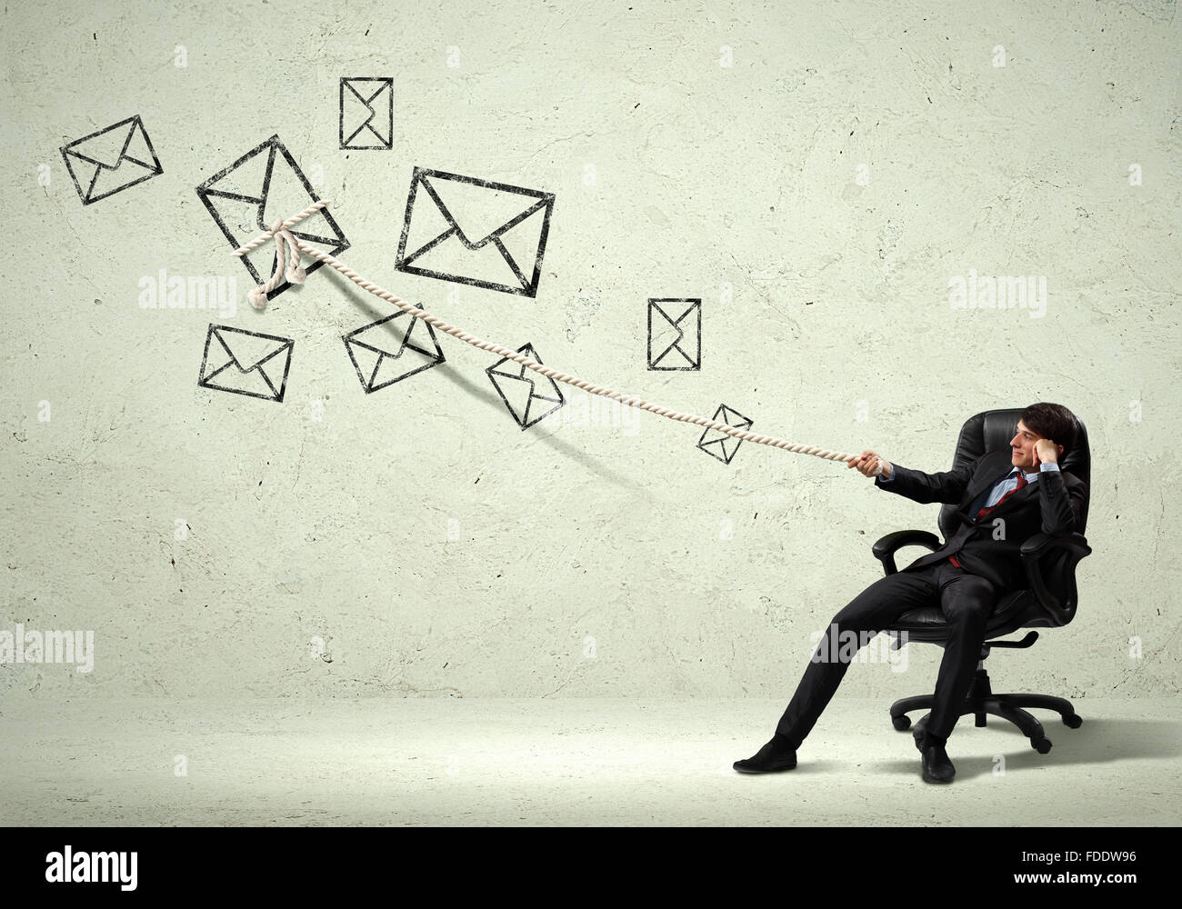 Image of young businessman pulling mail sign with rope Stock Photo - Alamy