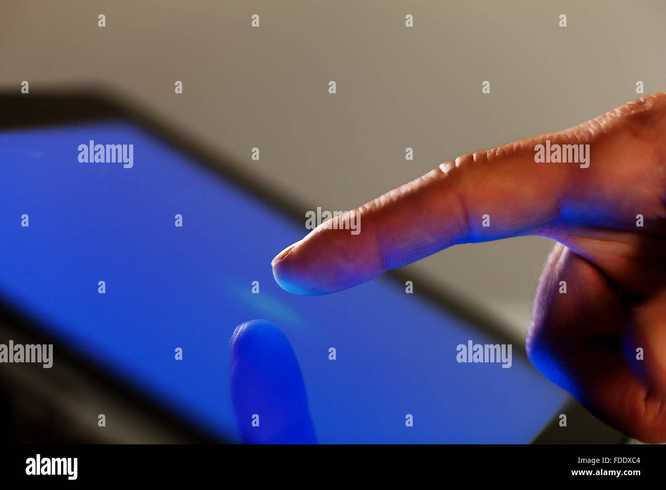 Close-up image of finger touching blue screen Stock Photo - Alamy