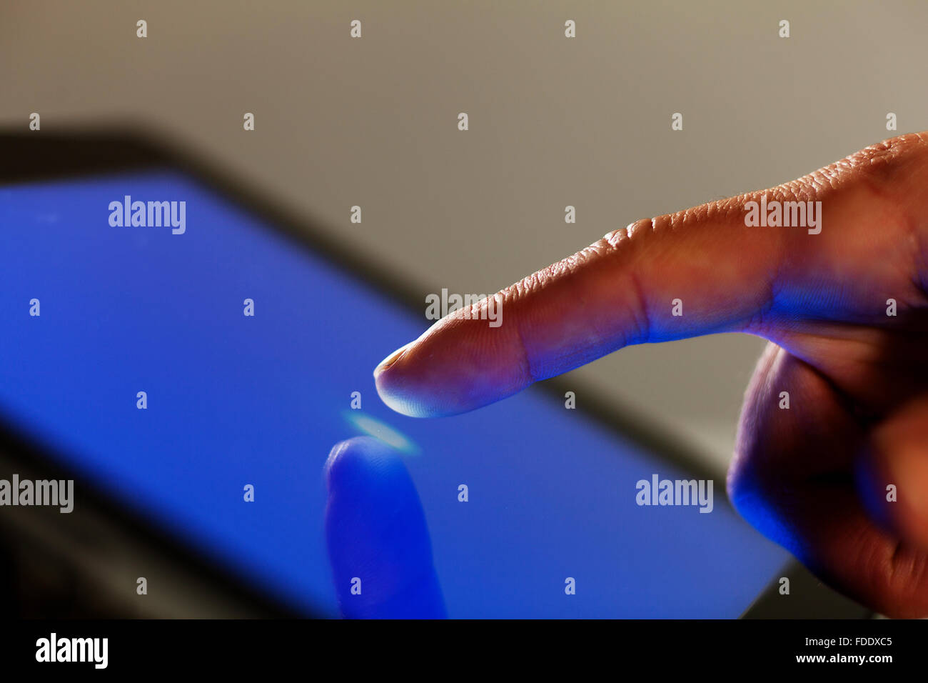 Close-up image of finger touching blue screen Stock Photo - Alamy