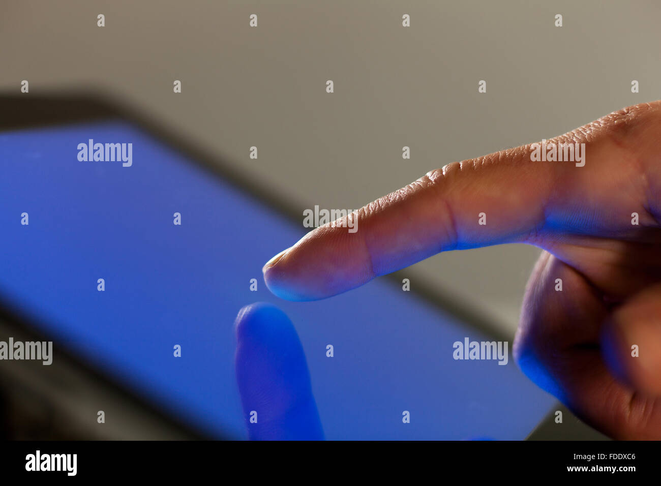Close-up image of finger touching blue screen Stock Photo - Alamy