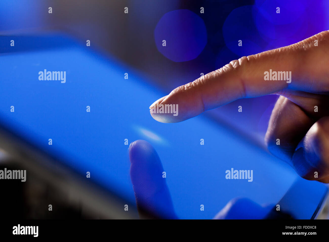 Close-up image of finger touching blue screen Stock Photo - Alamy