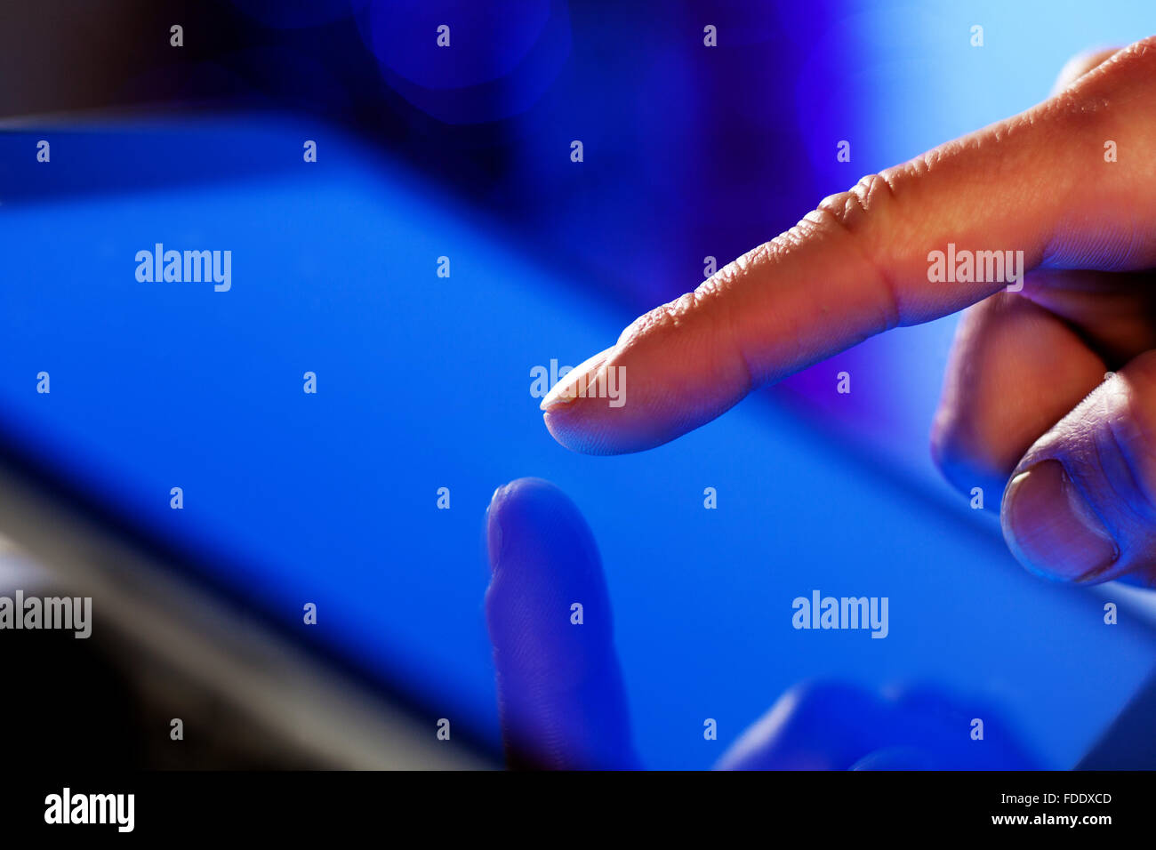 Close-up image of finger touching blue screen Stock Photo - Alamy