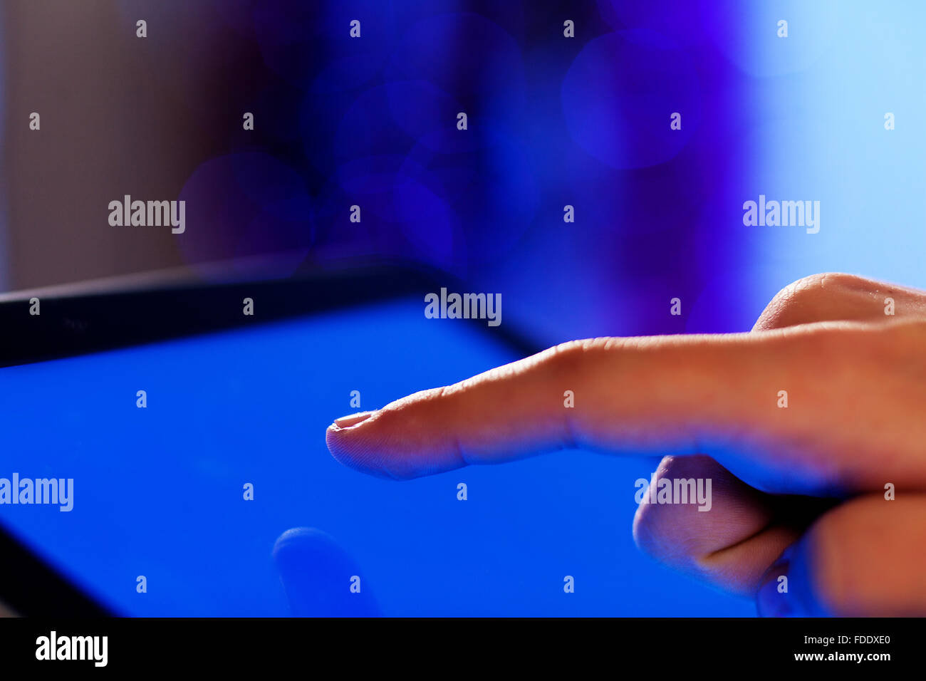Close-up image of finger touching blue screen Stock Photo - Alamy