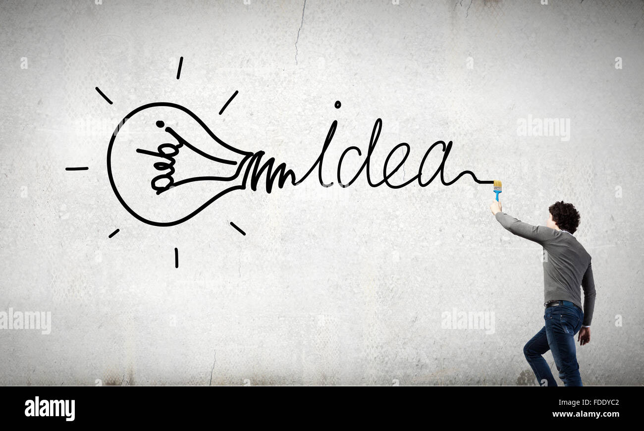 Young businessman standing with back and writing different words on ...