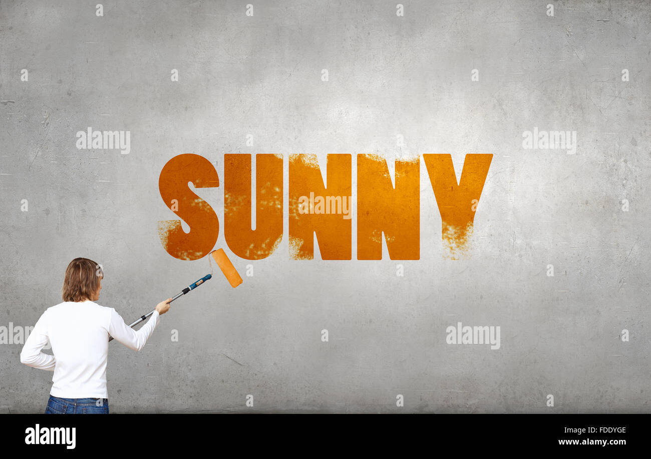 Back view of man painting word sunny in yellow Stock Photo - Alamy