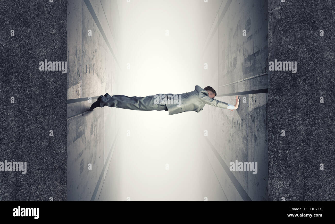 Young troubled businessman trapped between two walls Stock Photo - Alamy