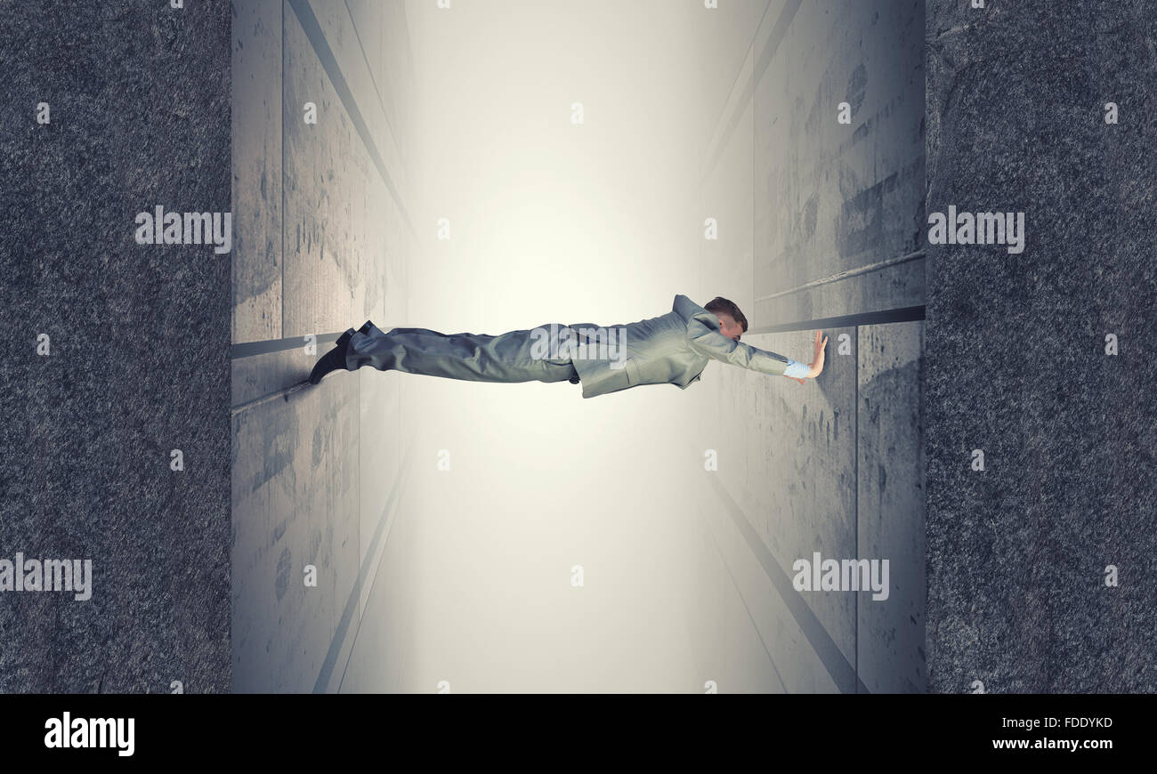 Young troubled businessman trapped between two walls Stock Photo - Alamy