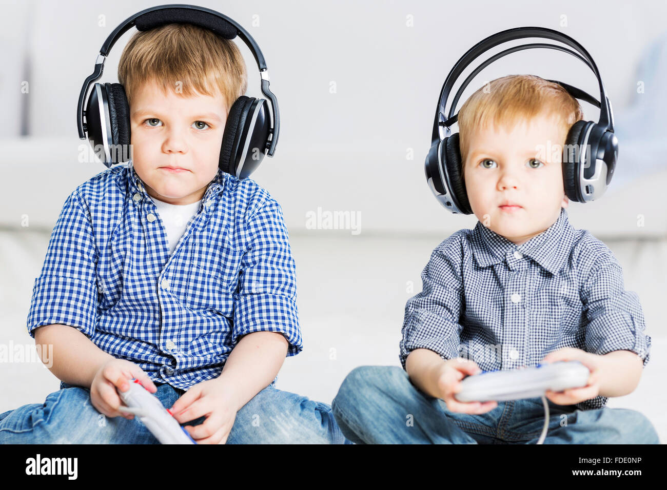Cute boys playing game in wireless headphones Stock Photo - Alamy