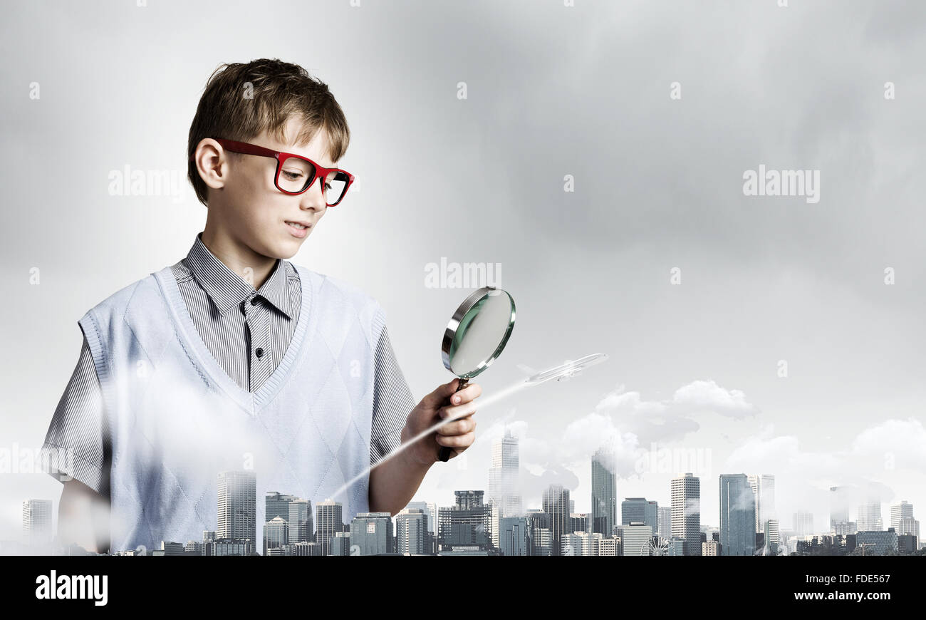 Cute school boy examining objects with magnifying glass Stock Photo - Alamy