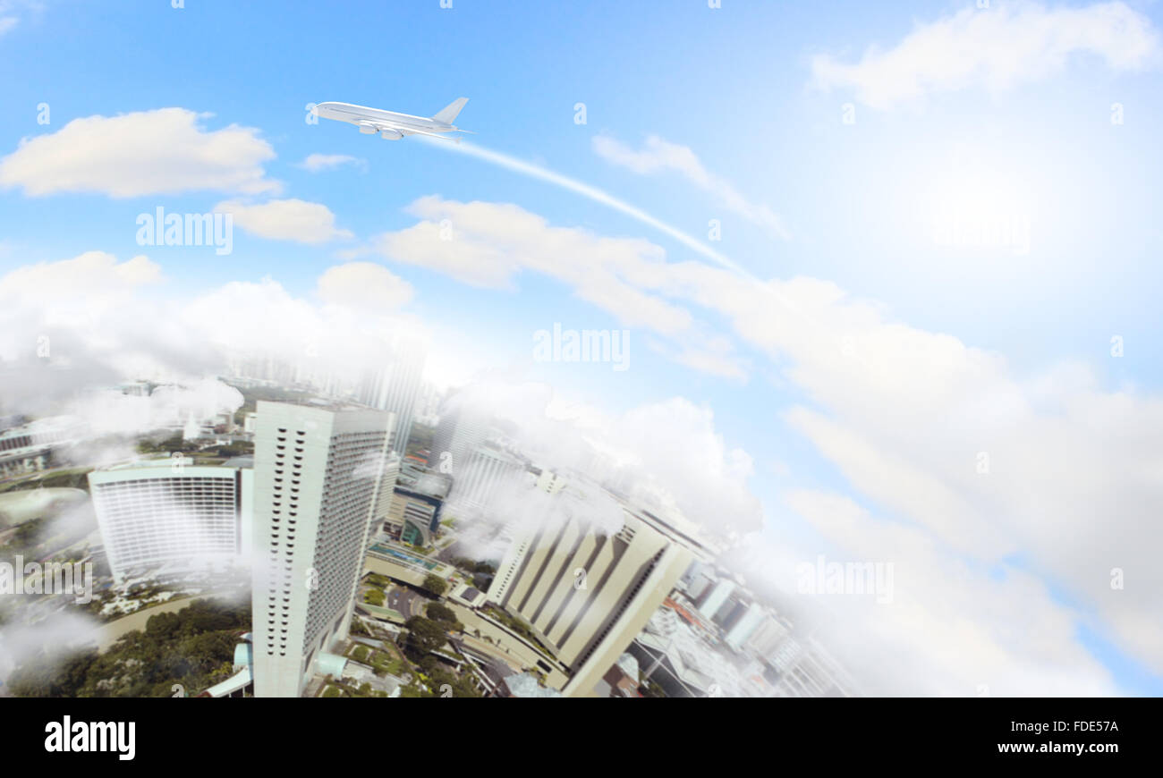 Airplane flying high in sky above city Stock Photo - Alamy