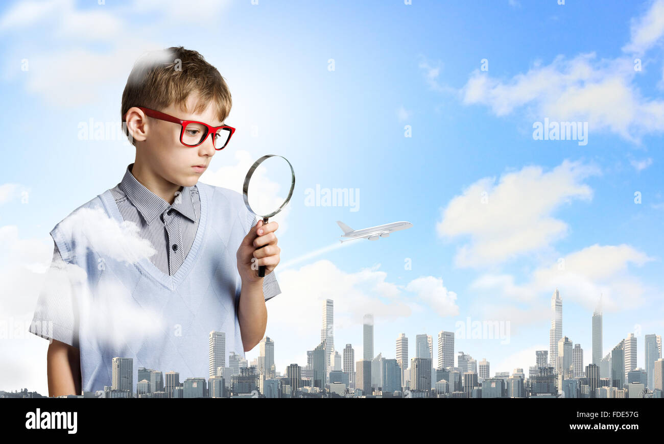 Cute school boy examining objects with magnifying glass Stock Photo - Alamy