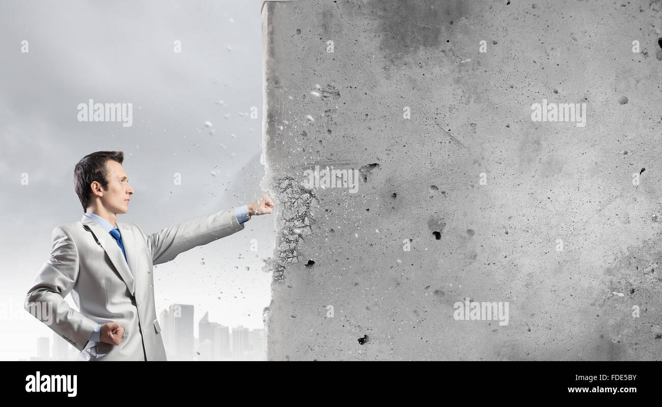 Businessman breaking stone wall with karate punch Stock Photo - Alamy