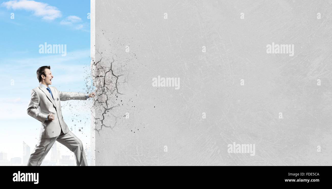 Businessman breaking stone wall with karate punch Stock Photo - Alamy