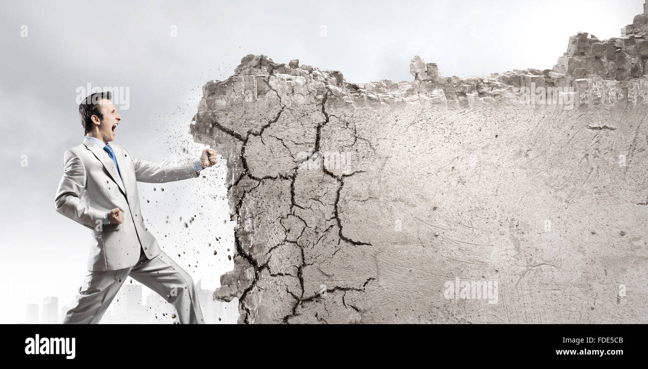 Businessman breaking stone wall with karate punch Stock Photo - Alamy