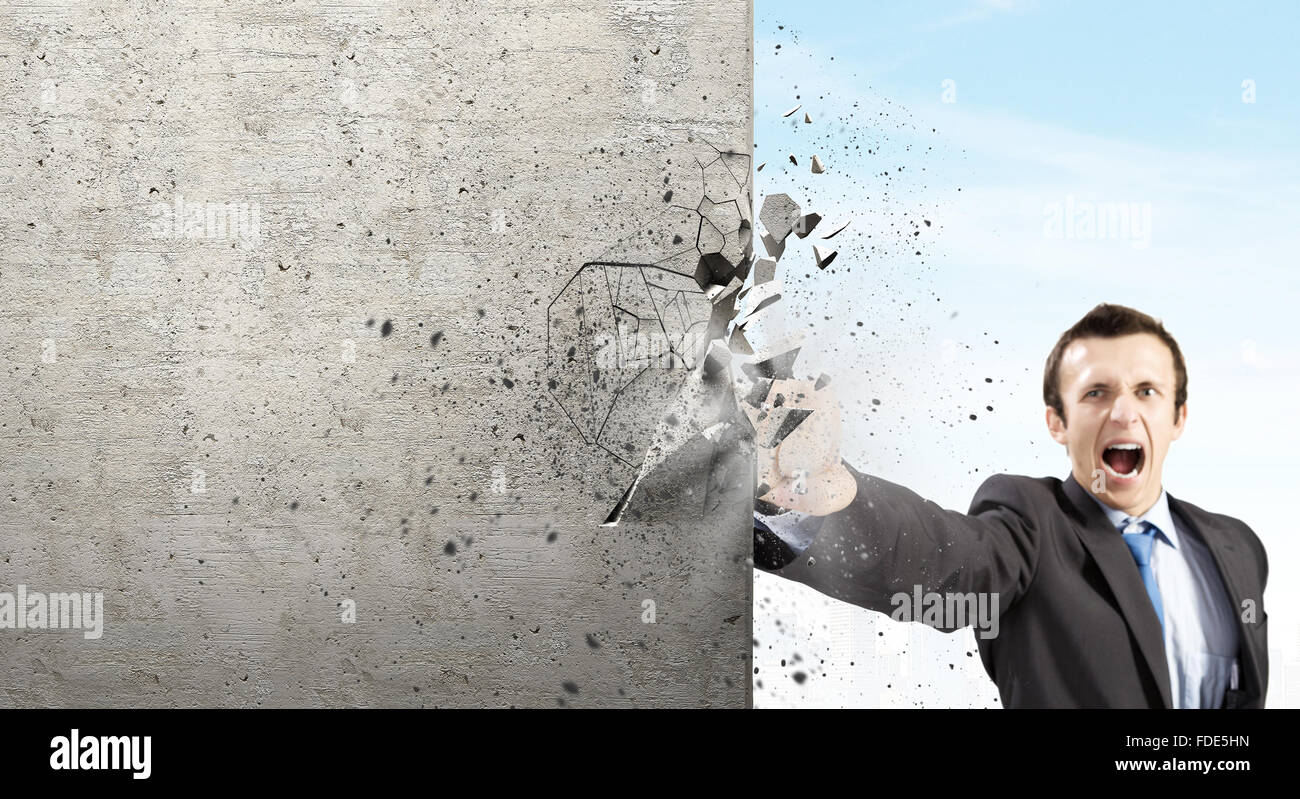 Businessman breaking stone wall with karate punch Stock Photo - Alamy