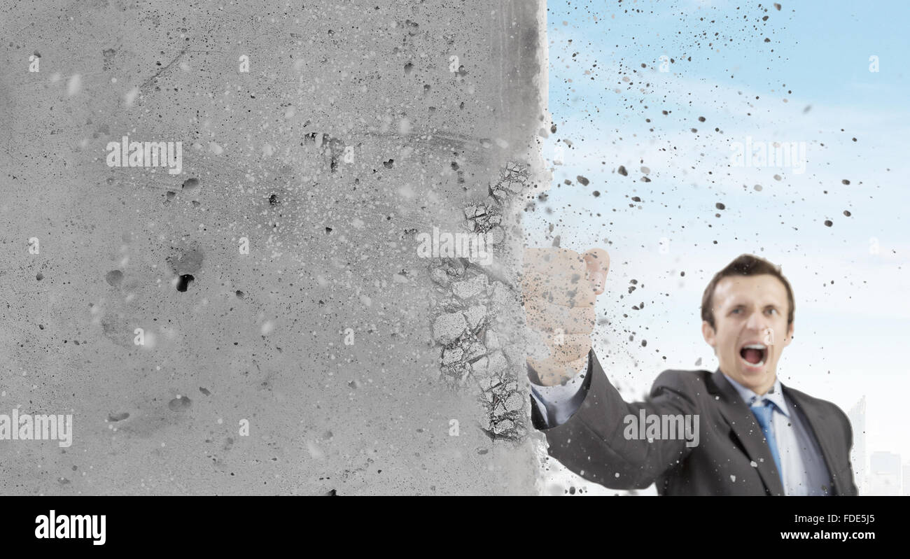 Businessman breaking stone wall with karate punch Stock Photo - Alamy