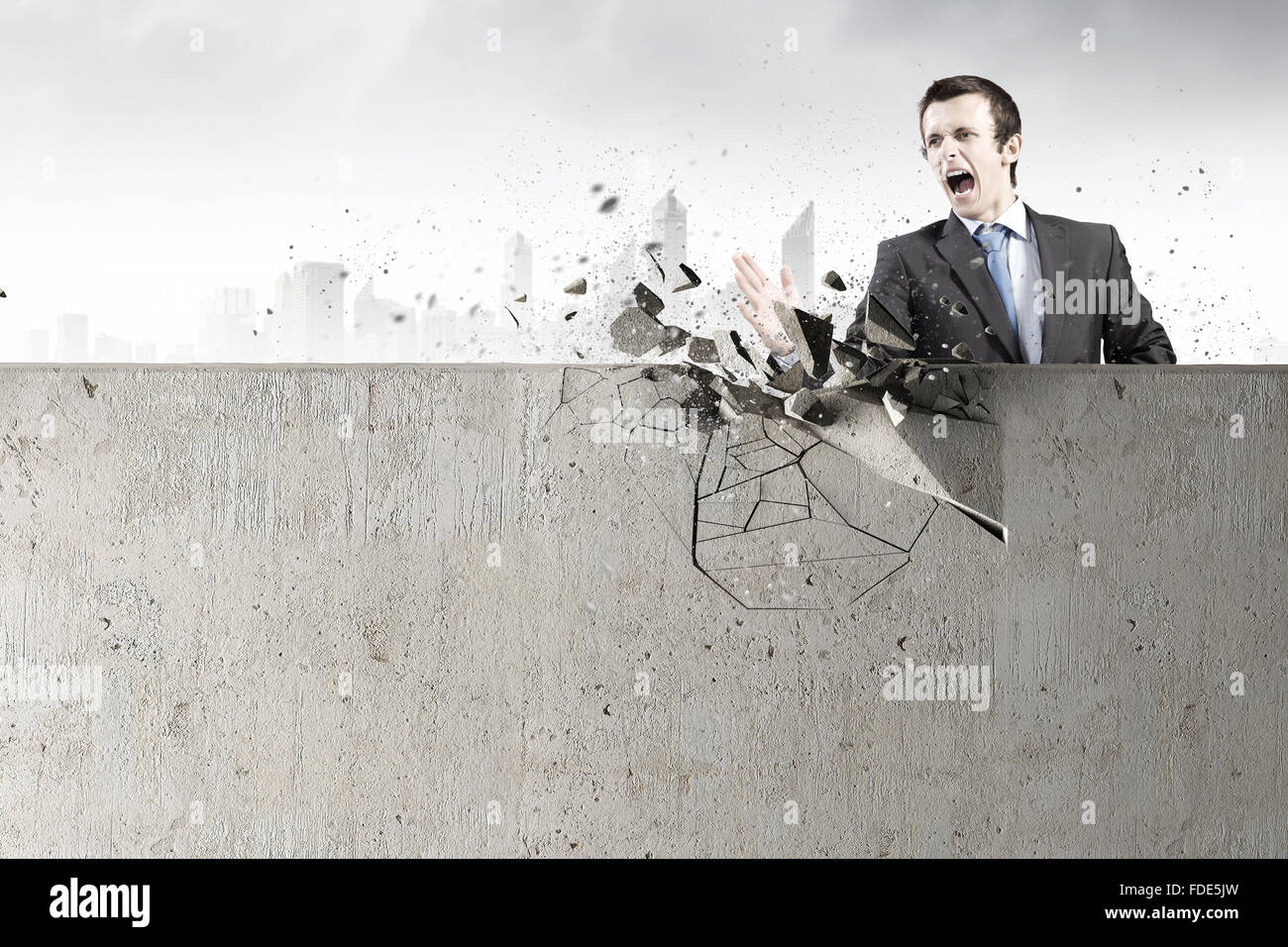 Businessman breaking stone wall with karate punch Stock Photo - Alamy