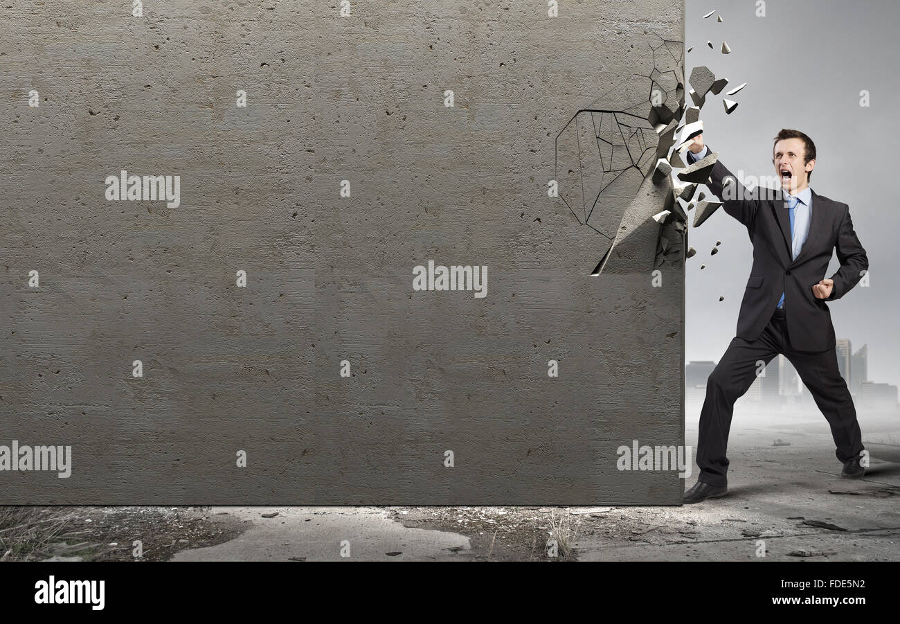 Businessman breaking stone wall with karate punch Stock Photo - Alamy