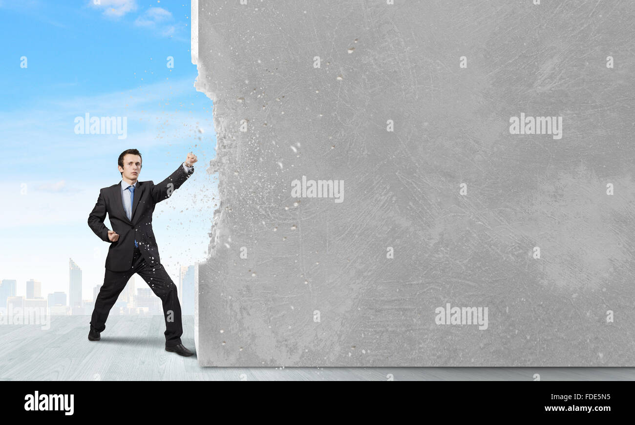 Businessman breaking stone wall with karate punch Stock Photo - Alamy