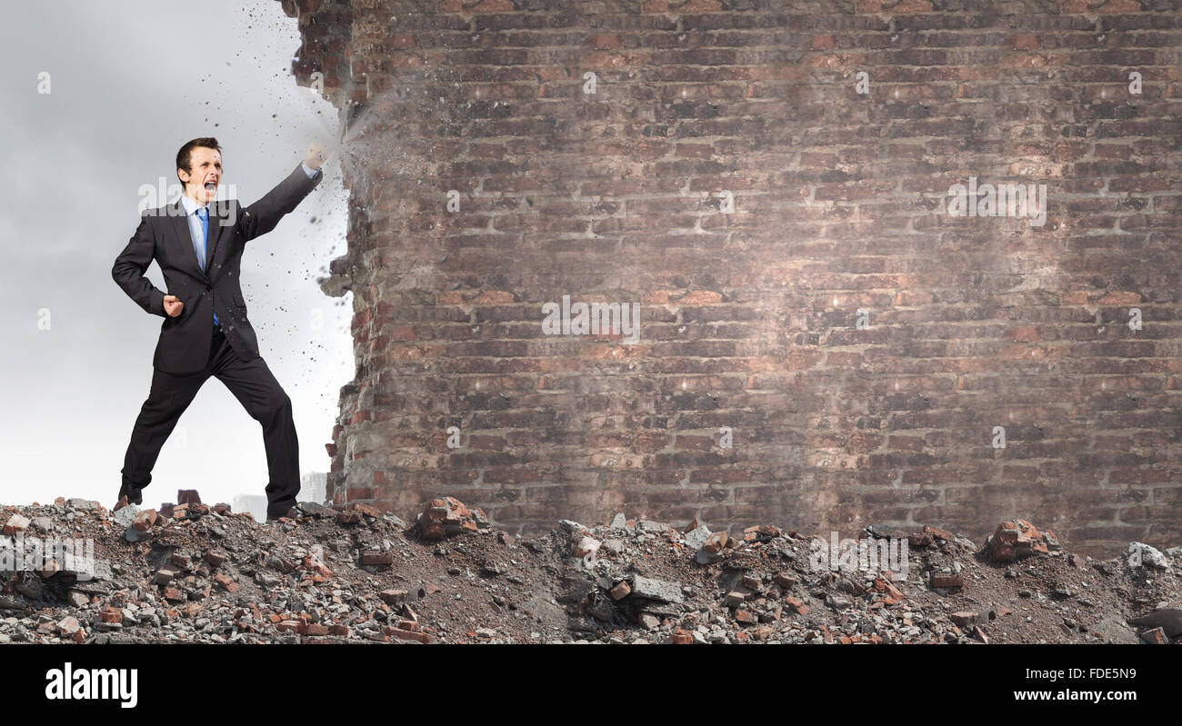 Businessman breaking stone wall with karate punch Stock Photo - Alamy