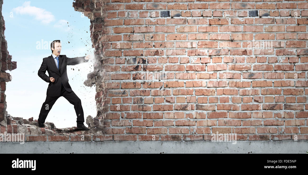 Businessman breaking stone wall with karate punch Stock Photo - Alamy