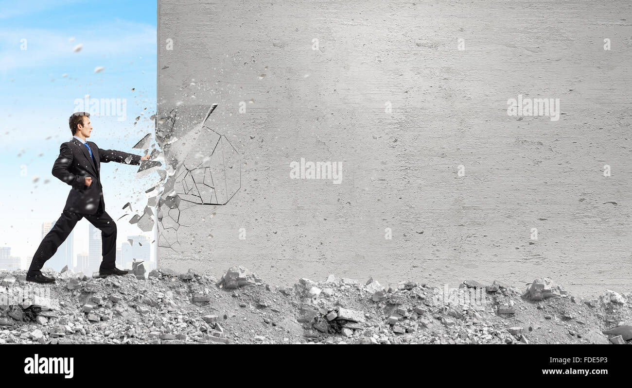 Businessman breaking stone wall with karate punch Stock Photo - Alamy