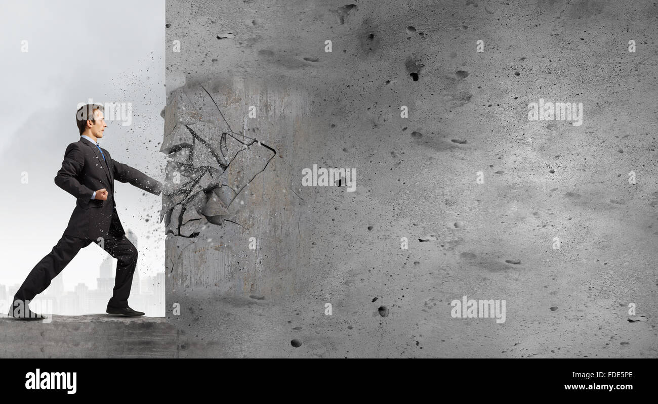 Businessman breaking stone wall with karate punch Stock Photo - Alamy