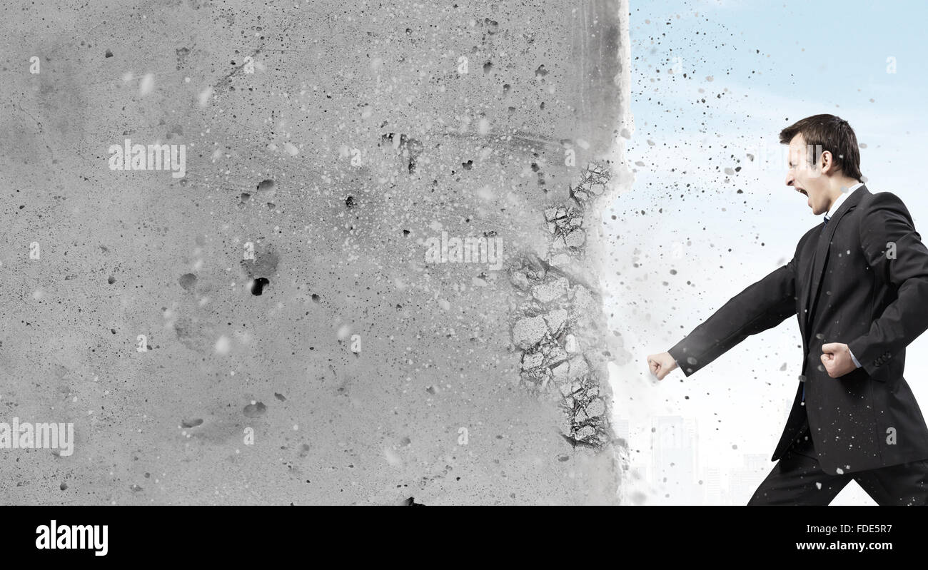 Businessman breaking stone wall with karate punch Stock Photo - Alamy