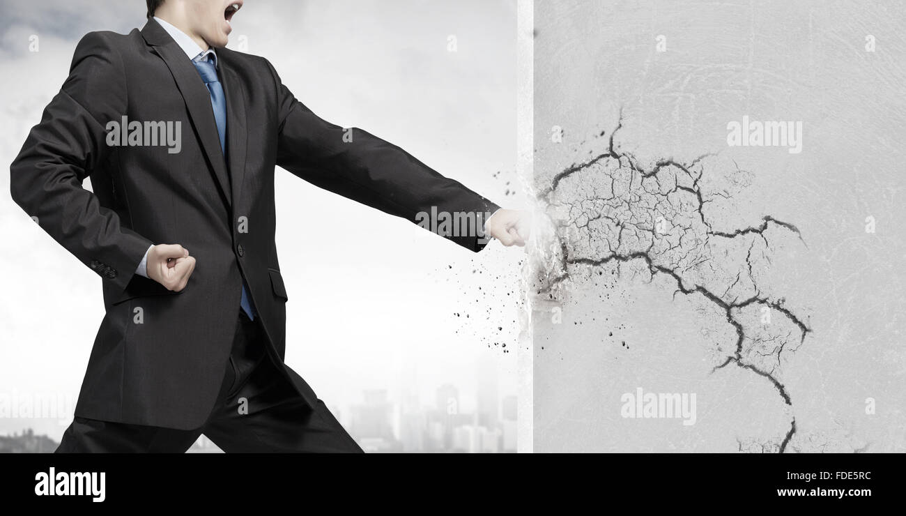 Businessman breaking stone wall with karate punch Stock Photo - Alamy