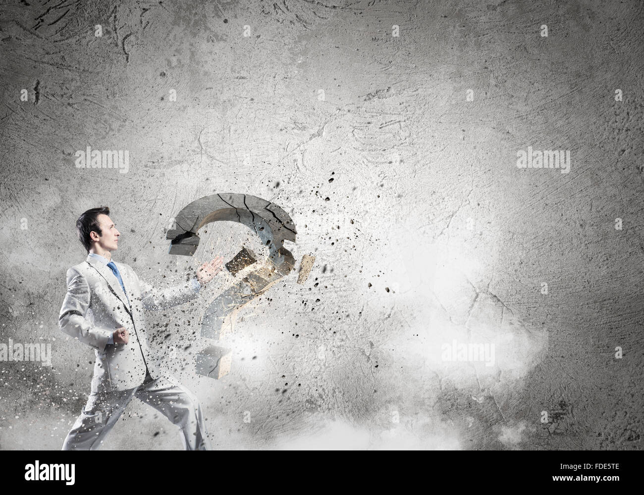 Businessman breaking stone question mark with karate kick Stock Photo ...