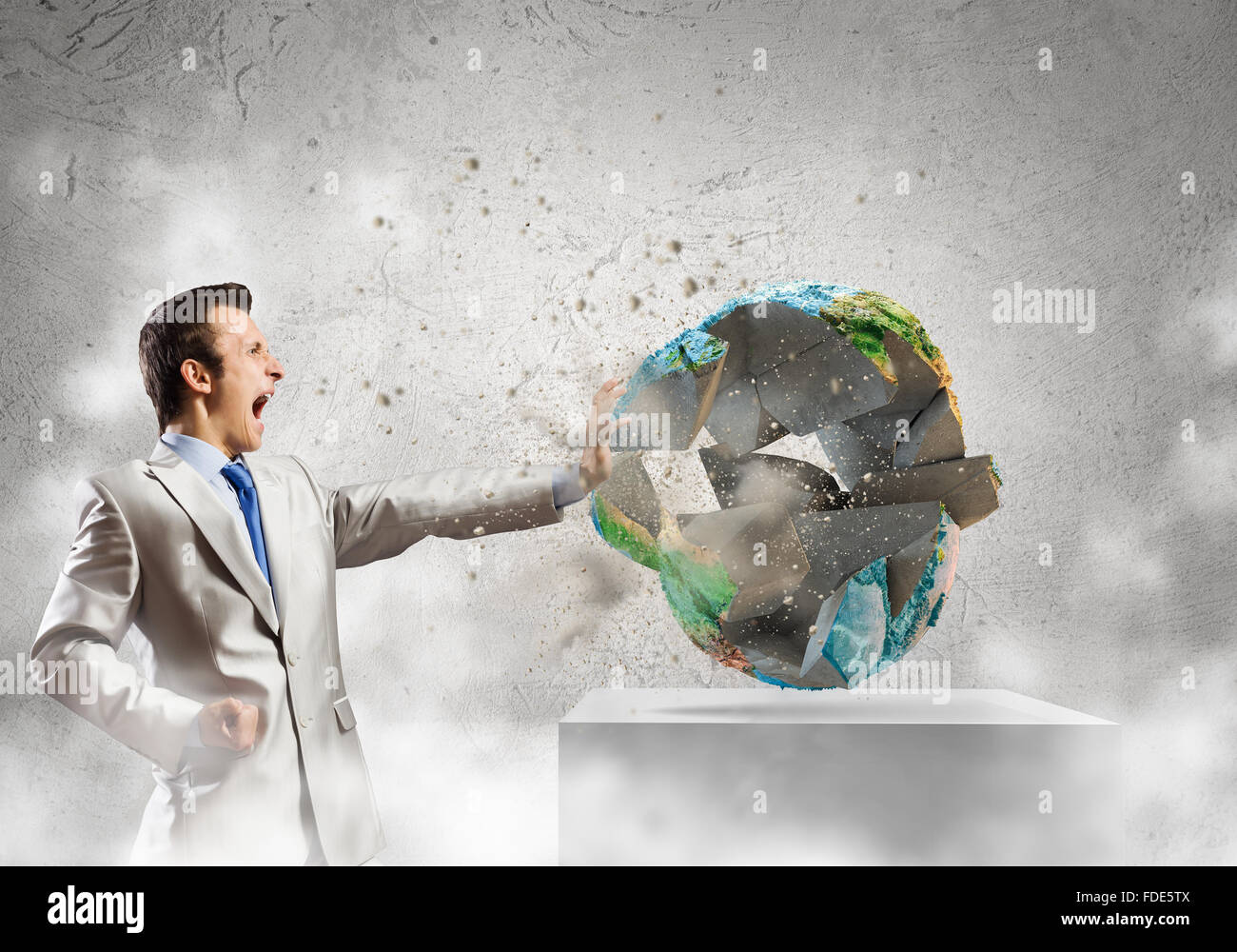 Young determined businessman crashing Earth planet with punch. Elements ...