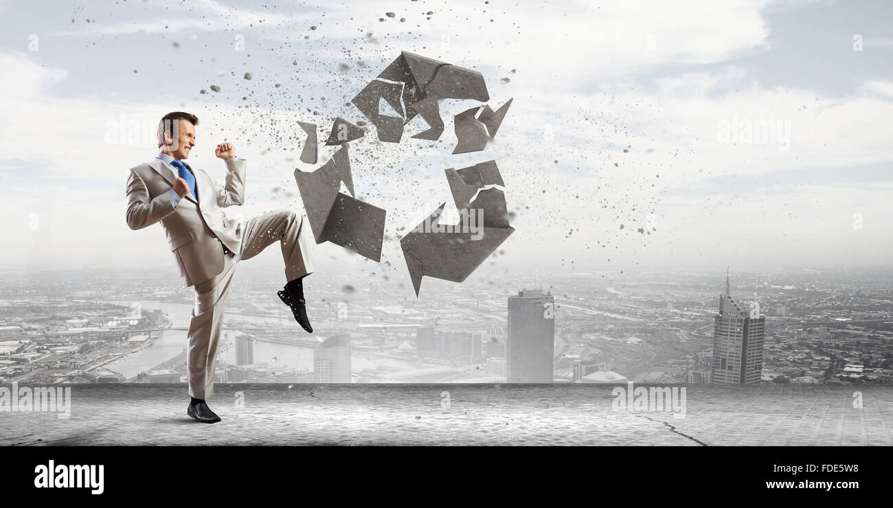 Businessman breaking recycle stone sign with karate kick Stock Photo ...